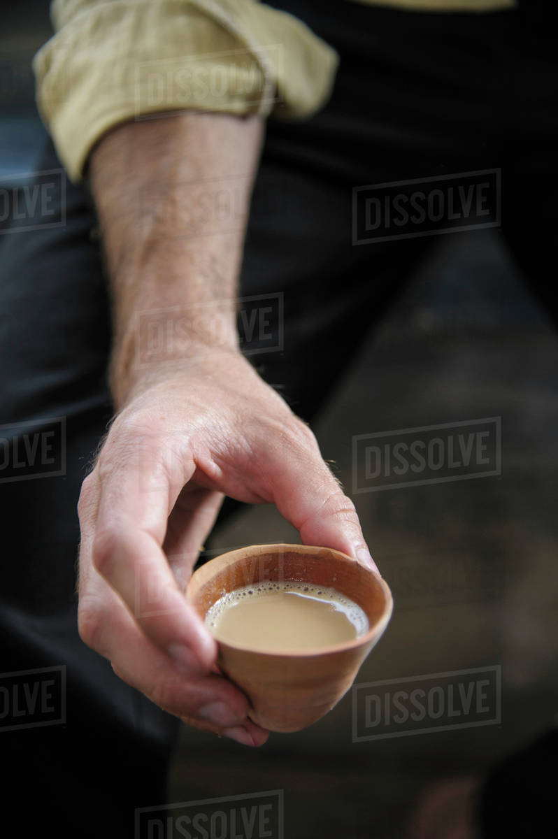 Hand holding cup of tea - Stock Photo - Dissolve