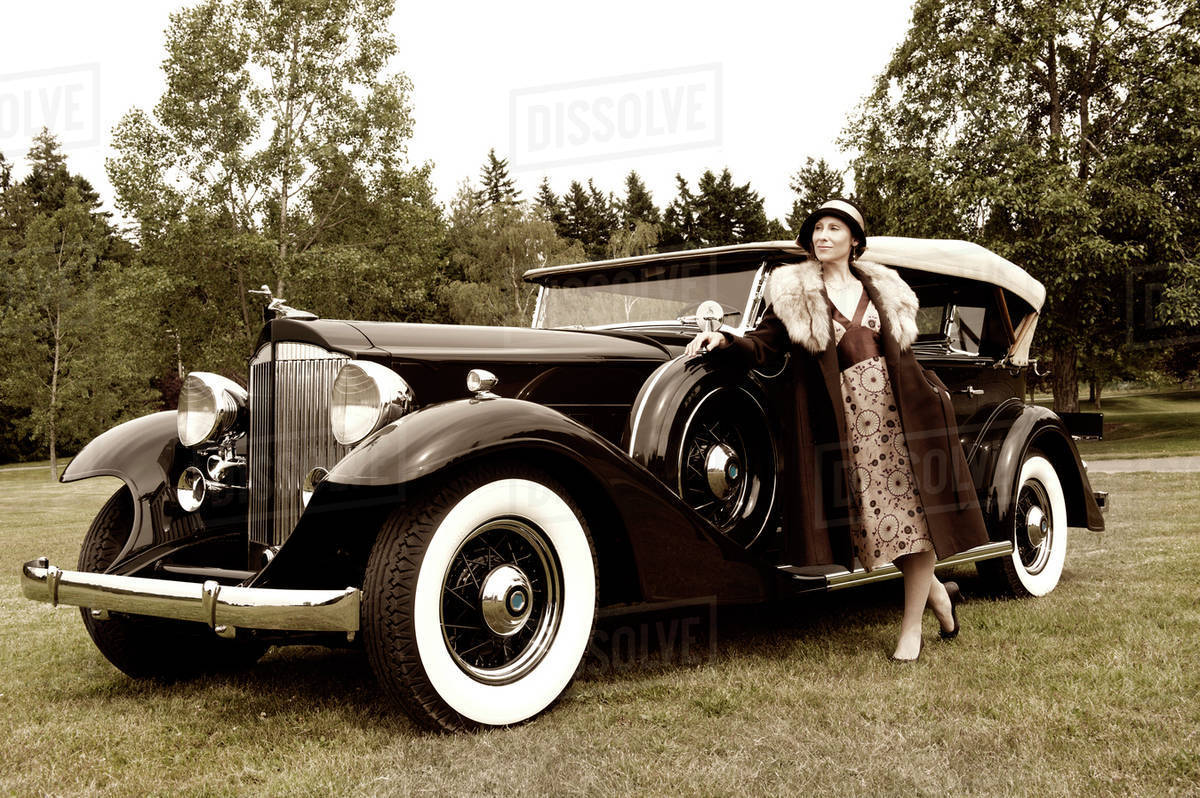 Caucasian woman by vintage car - Royalty-free Stock Photo | Dissolve