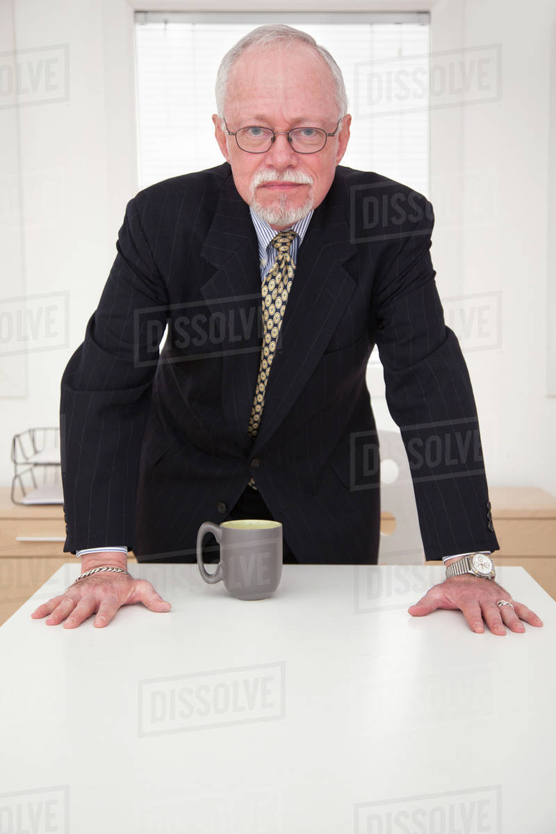 Caucasian businessman leaning over table - Royalty-free Stock Photo ...