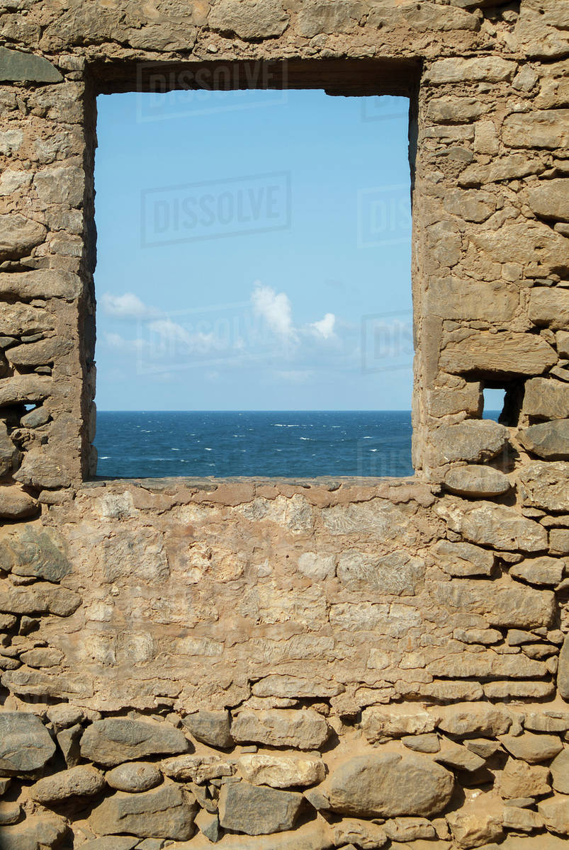 Ocean viewed through window of stone wall - Stock Photo - Dissolve
