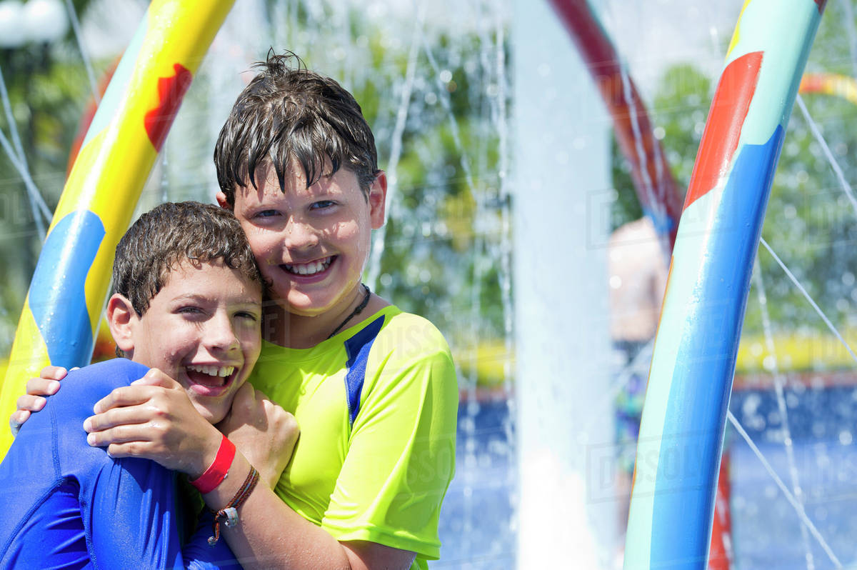 Hispanic children playing at water park - Stock Photo - Dissolve