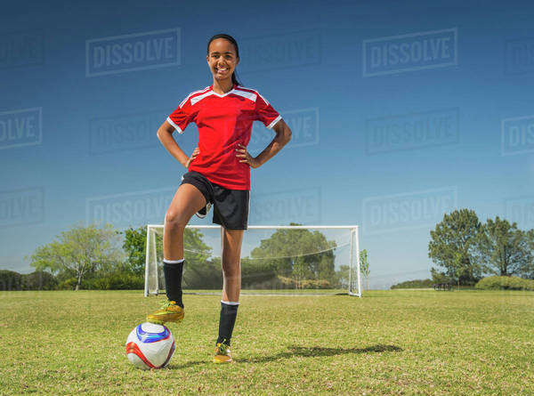 Mixed race soccer player standing on field - Royalty-free Stock Photo ...