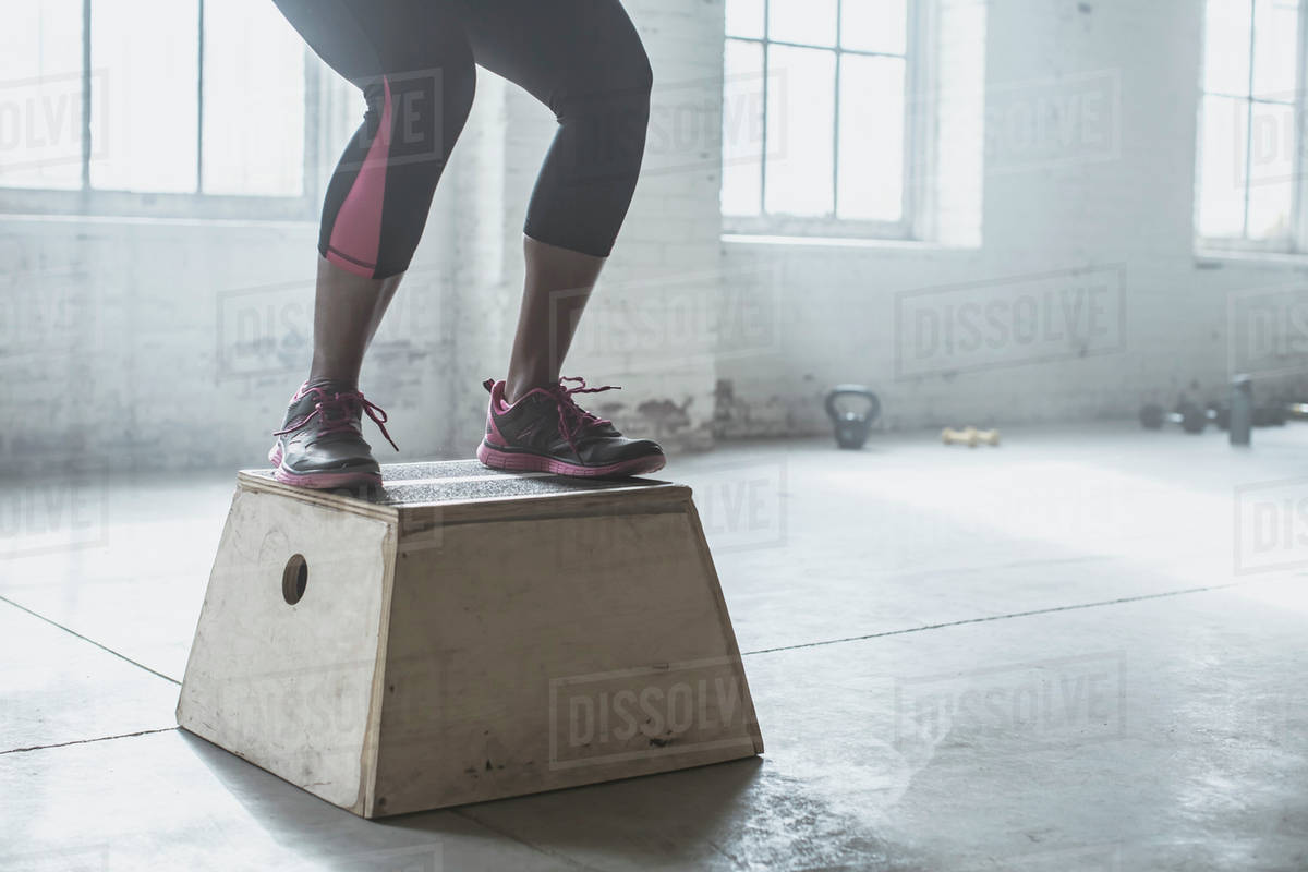 Athlete jumping on platform in gym - Royalty-free Stock Photo | Dissolve