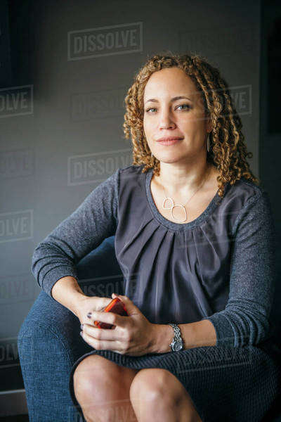 Mixed race businesswoman smiling in armchair - Royalty-free Stock Photo ...