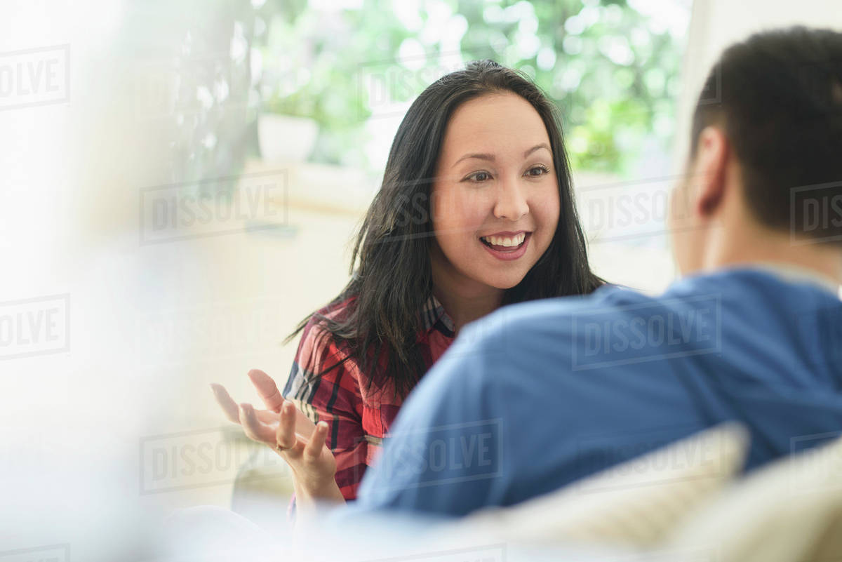 Couple talking on sofa in living room - Royalty-free Stock Photo | Dissolve