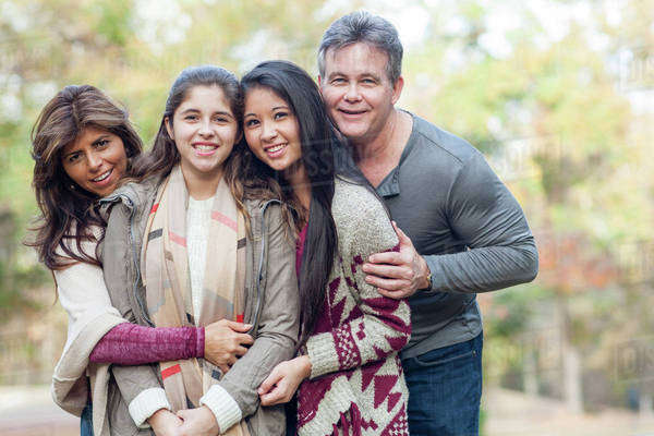 Hispanic family hugging outdoors - Royalty-free Stock Photo | Dissolve