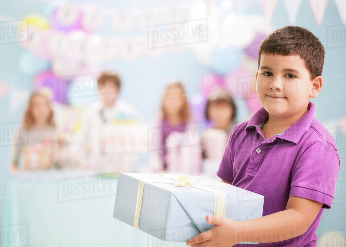 Boy holding wrapped gift at birthday party - Royalty-free Stock Photo ...