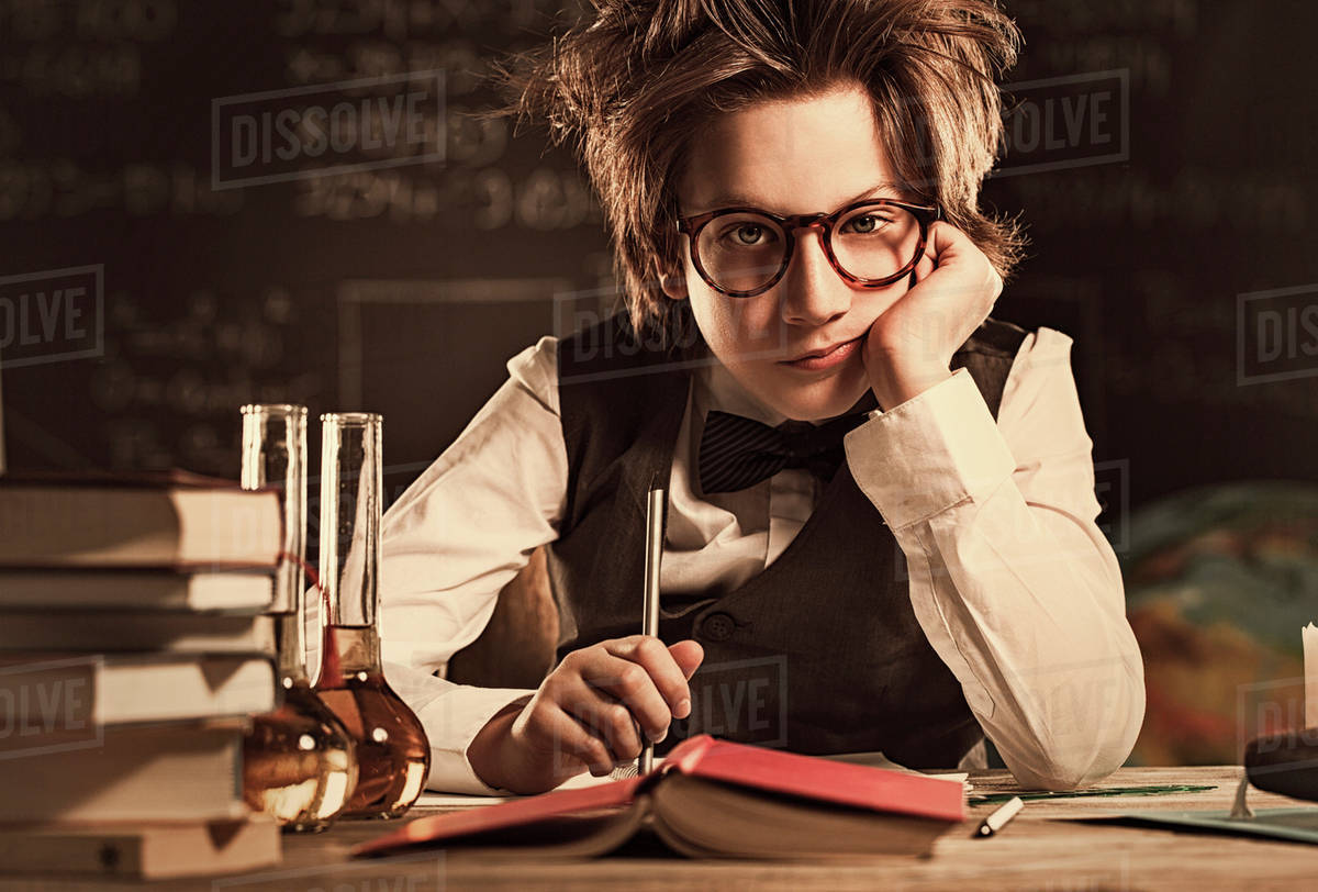 Bored student sitting at desk in classroom - Stock Photo - Dissolve