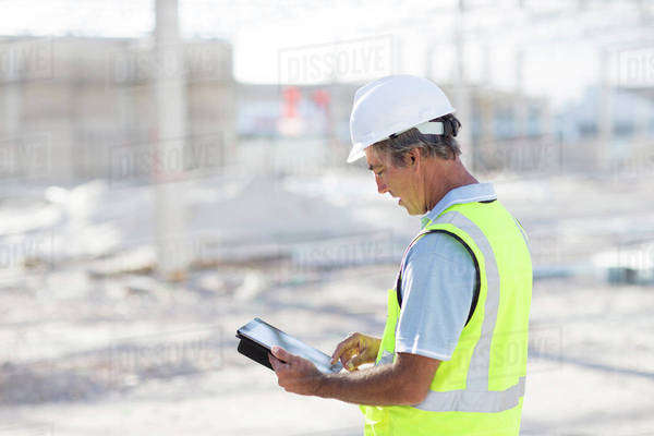 Caucasian architect using digital tablet at construction site - Royalty ...