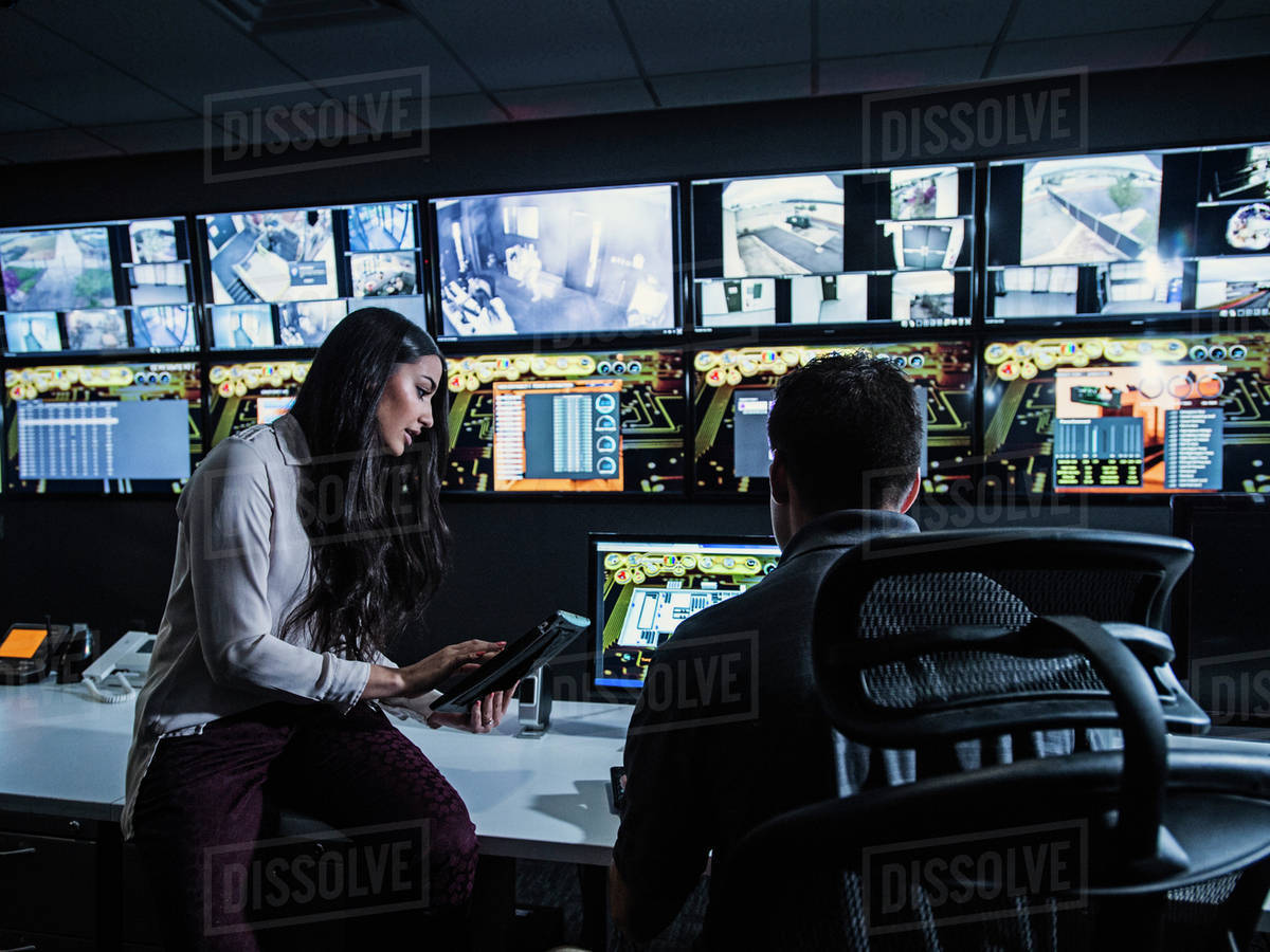 Security guards watching monitors in control room - Stock Photo - Dissolve