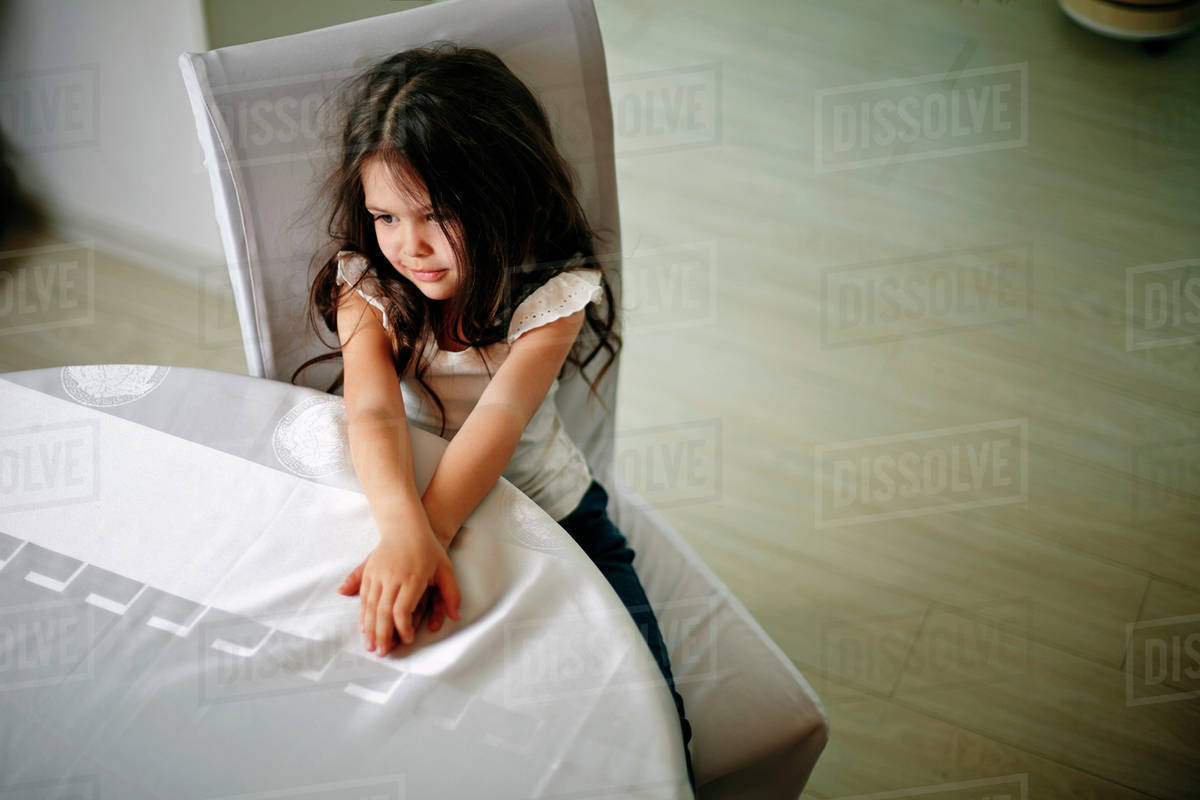 Caucasian girl sitting at table - Royalty-free Stock Photo | Dissolve