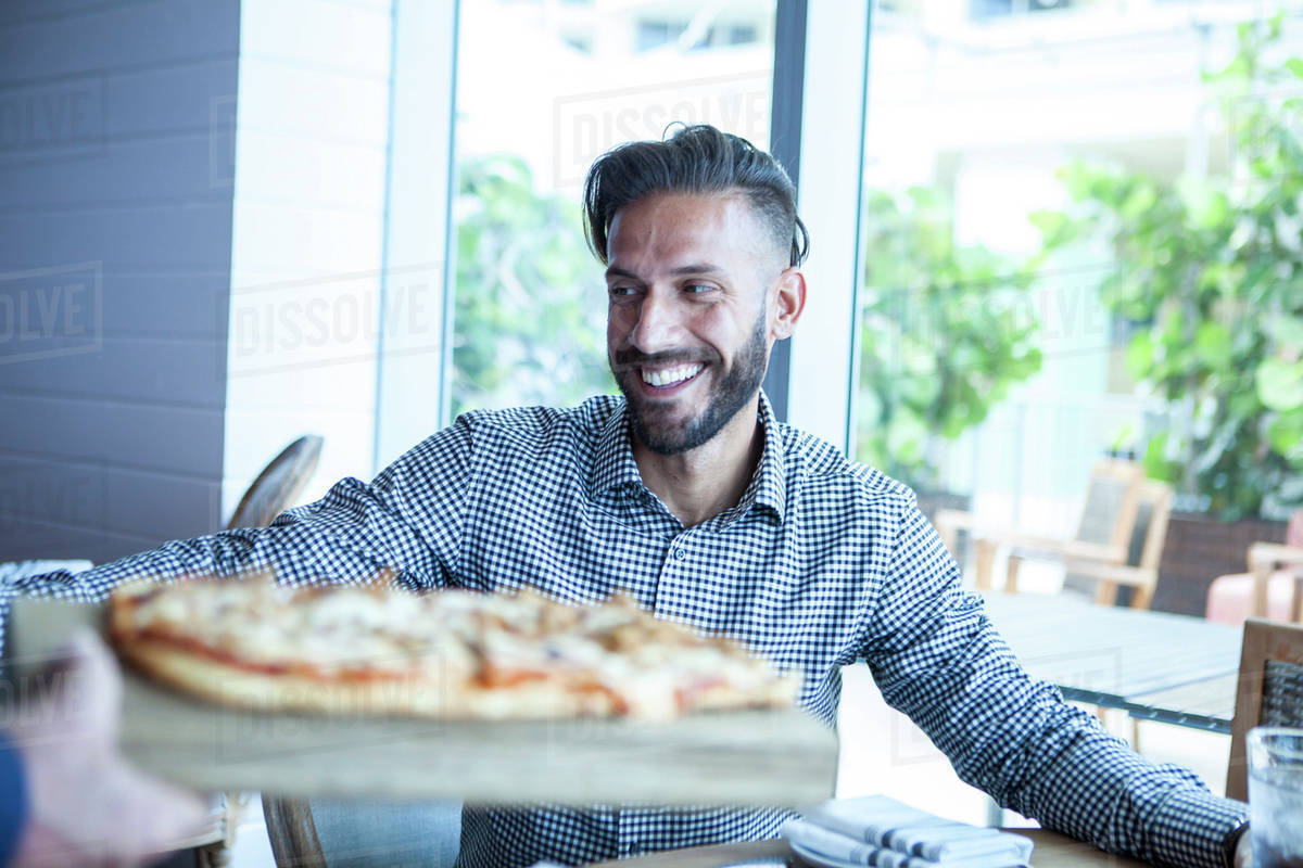 Server bringing diner pizza in restaurant - Stock Photo - Dissolve