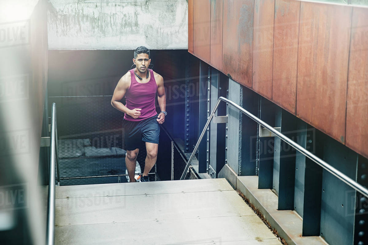 Indian man jogging on city steps - Royalty-free Stock Photo | Dissolve