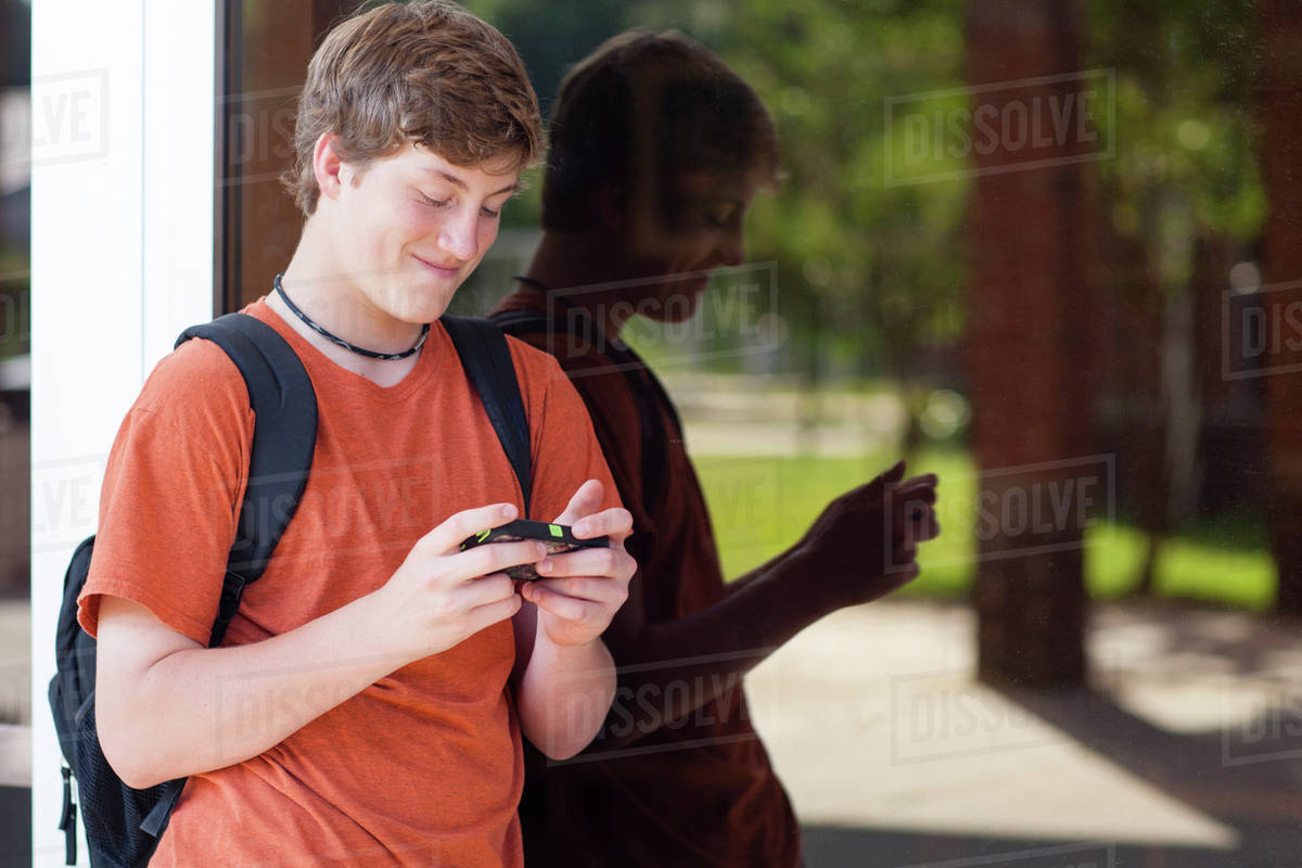 Caucasian teenage boy using cell phone - Stock Photo - Dissolve