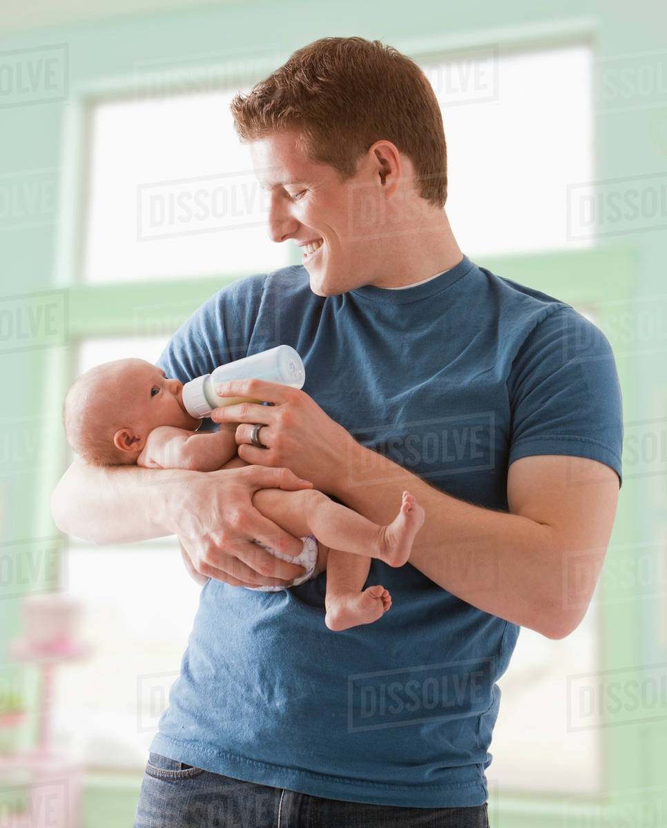 Caucasian father feeding baby girl - Royalty-free Stock Photo | Dissolve