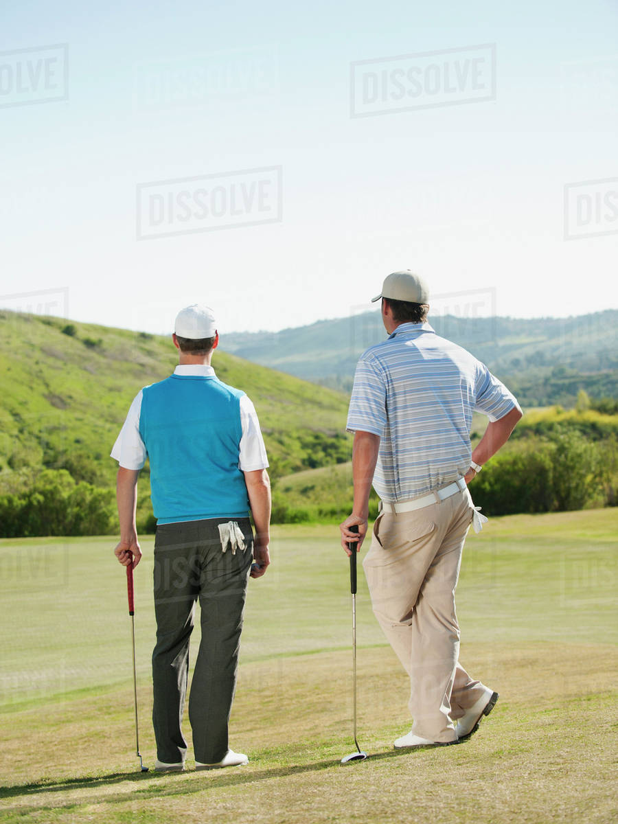Caucasian men playing golf together on golf course - Stock Photo - Dissolve