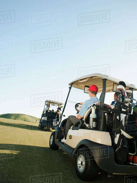 Men driving golf carts on golf course - Royalty-free Stock Photo | Dissolve