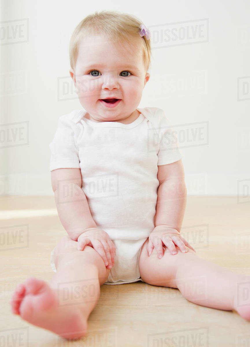 Caucasian baby sitting on floor - Royalty-free Stock Photo | Dissolve