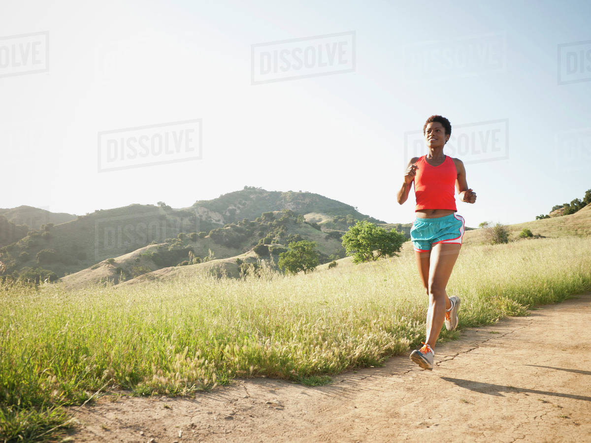 Mixed race woman running on remote trail - Stock Photo - Dissolve