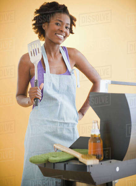 Black woman grilling on barbecue - Royalty-free Stock Photo | Dissolve