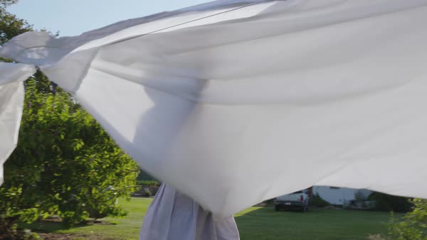 Slow motion shot of a woman stroking bed sheet on a clothesline - HD ...