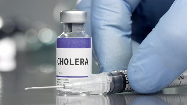 Cholera vaccine vial in medial lab with syringe placed next to it while ...