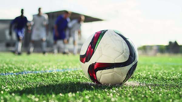 Close up of a soccer ball being kicked by a player in slow motion, with ...