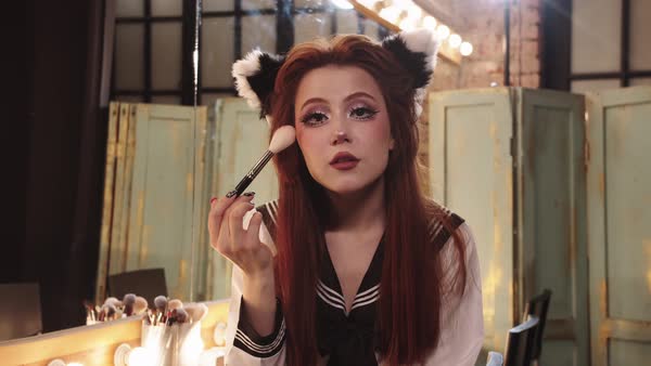 Cute and beautiful young woman with catchy anime makeup applying ...