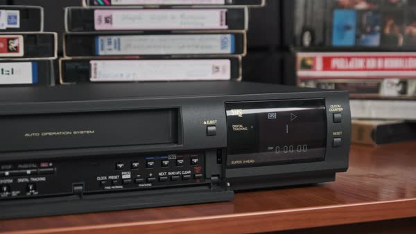 Insert VHS cassette into VCR and push play button. Black vintage ...