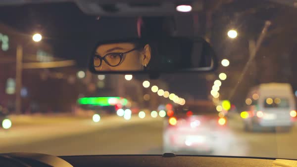 Woman driving her car and her face reflected in rear-view mirror - HD ...
