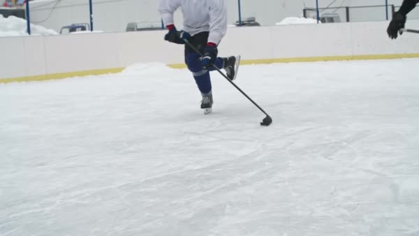 Hockey defenseman falling down on ice while knocking the puck off the ...