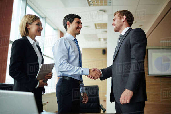 Two happy men greeting one another after making business agreement ...
