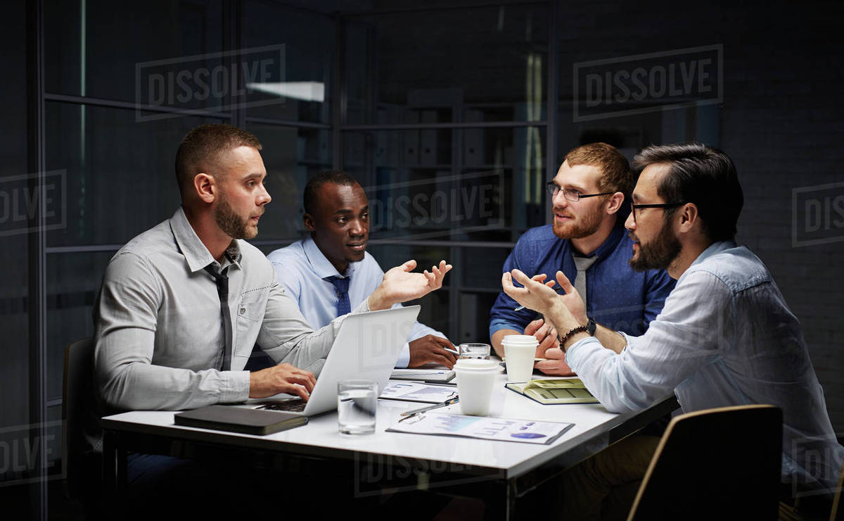 Group of young men planning work late in the evening - Royalty-free ...
