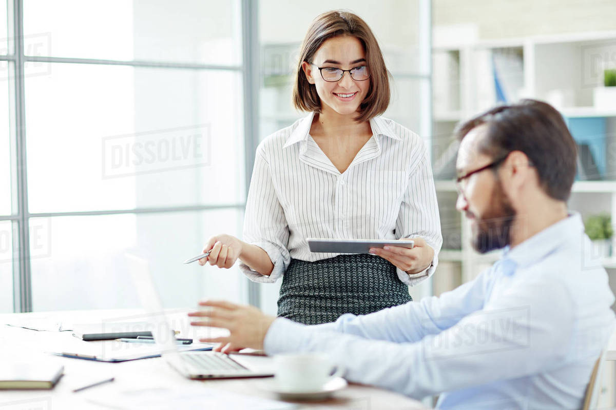 Employee explaining her idea to colleague at meeting - Royalty-free ...