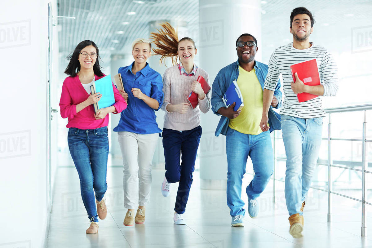 Happy students running together along the corridor - Royalty-free Stock ...