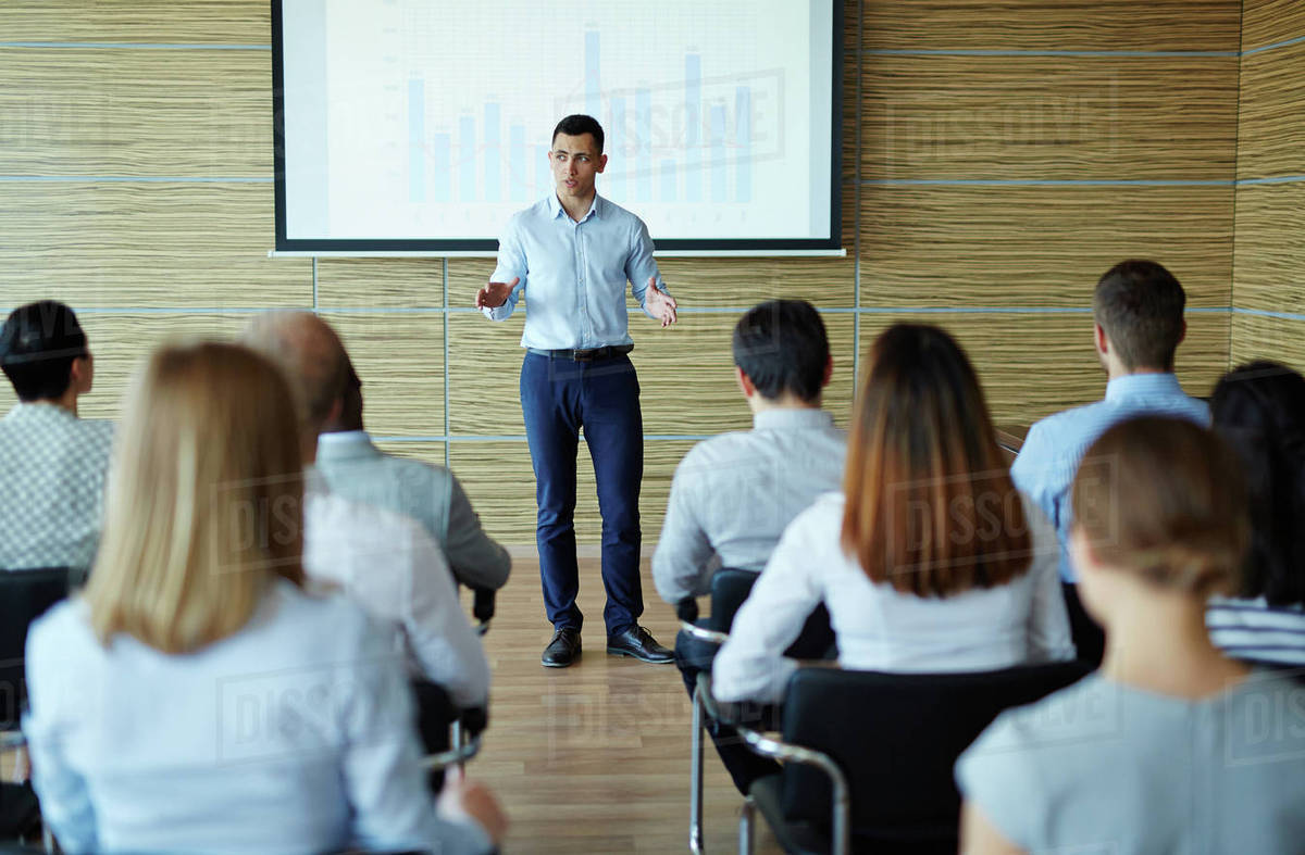 Businessman reading lecture to his colleagues at presentation of new ...
