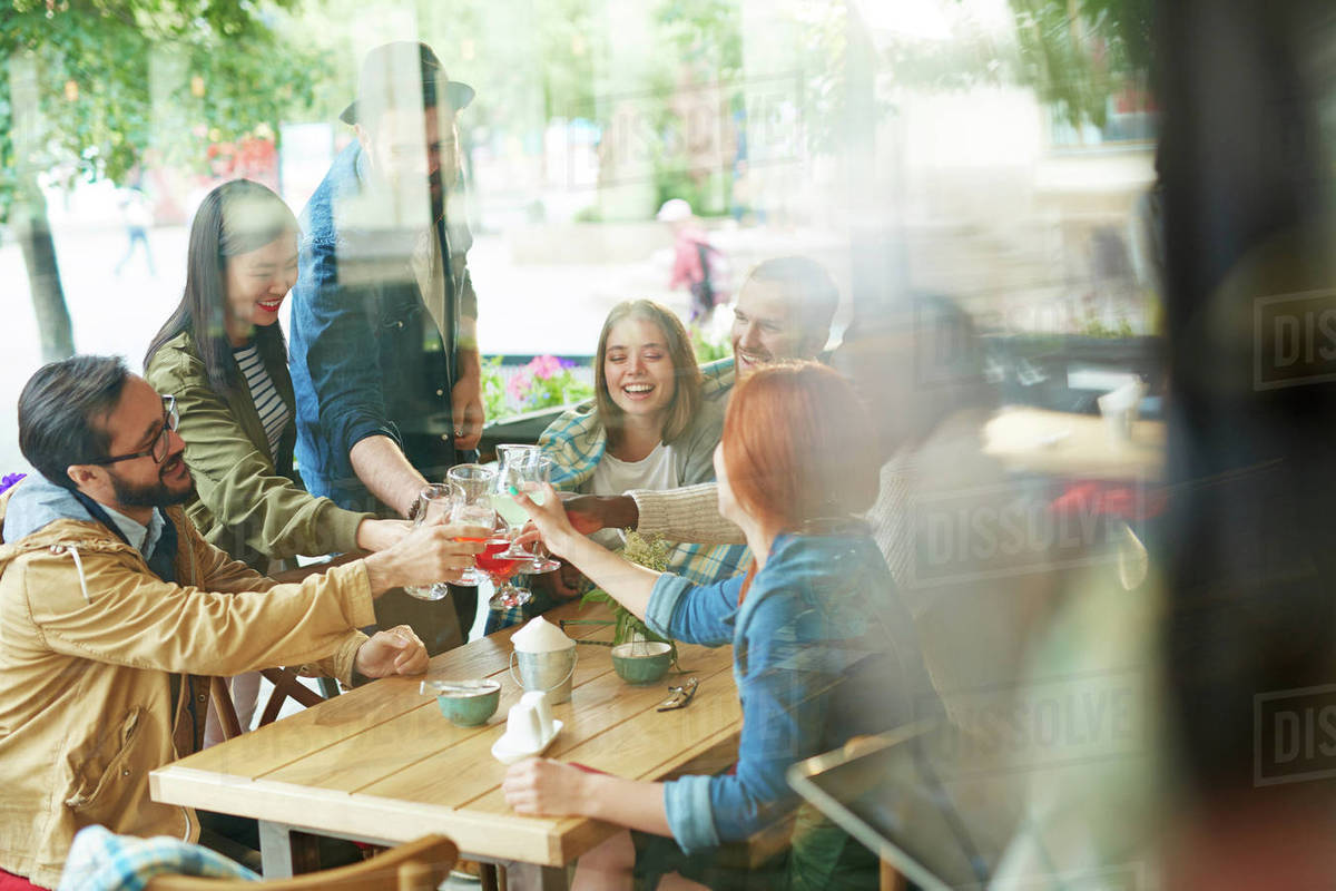 Happy people sitting at the table and toasting - Royalty-free Stock ...