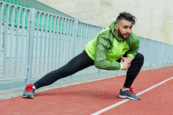 Attractive young man stretching on the rack track - Royalty-free Stock ...