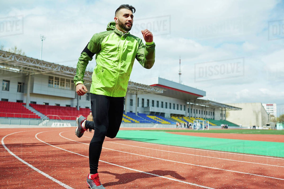Active man jogging around race track in the morning - Royalty-free ...