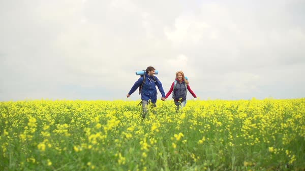 Slow motion of girl and boy running towards each other in the meadow ...