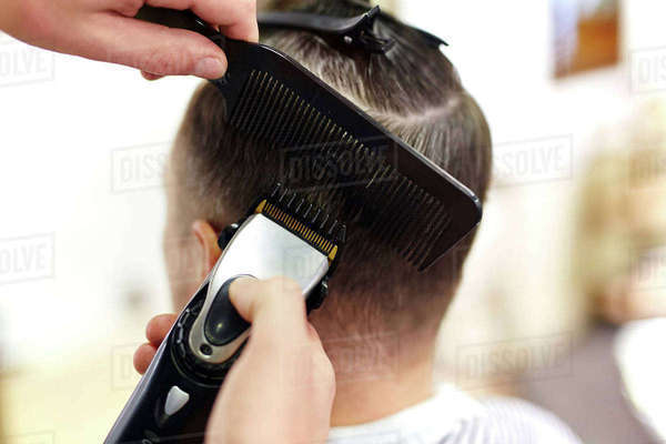 Barber trimming male hair with hair clipper - Royalty-free Stock Photo ...