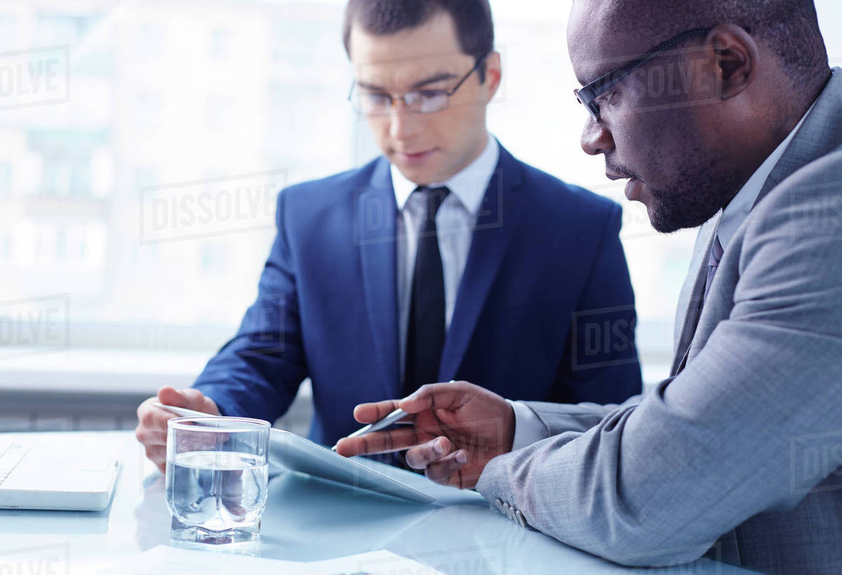 Two serious partners discussing their plans with touchpad - Royalty ...