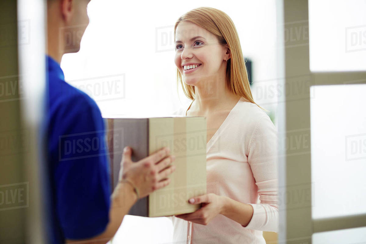 Pretty woman receiving package from delivery man - Royalty-free Stock ...