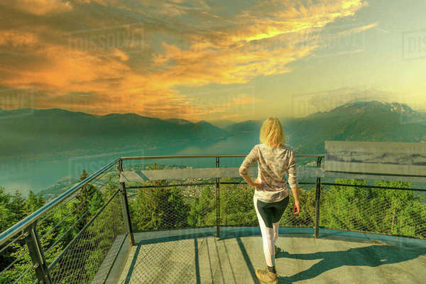 Woman at sunset on top of Cardada-Cimetta mount in Switzerland. Skyline ...