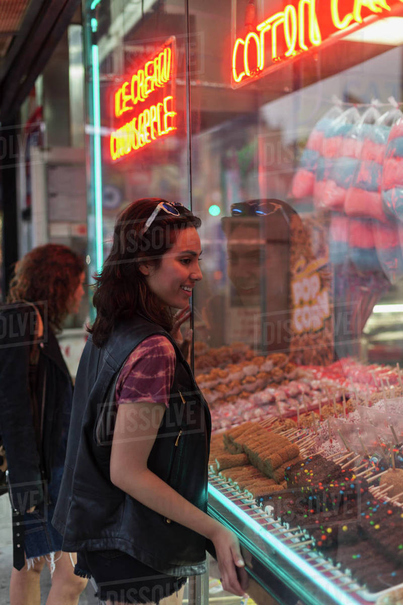 Young woman looking at a store front - Stock Photo - Dissolve