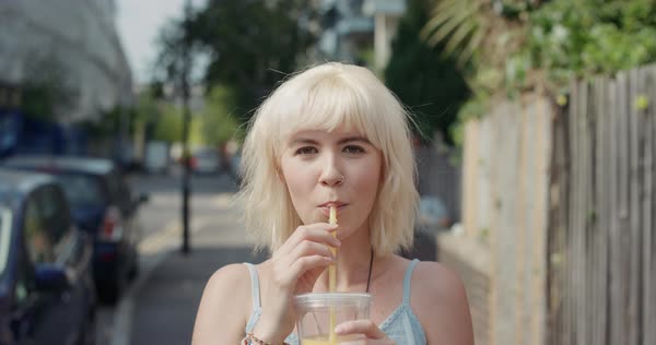 Portrait of happy beautiful woman drinking juice wearing nose ring in ...