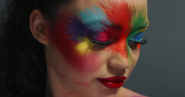 Close up portrait of an attractive woman wearing colorful face paint ...