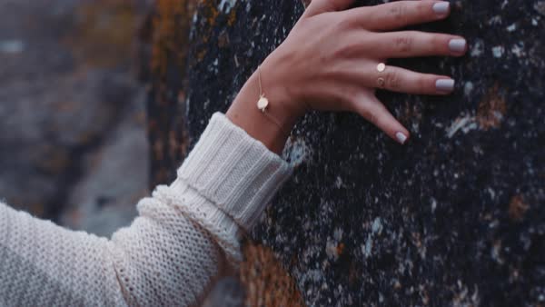 Close up woman hand touching rock exploring seaside enjoying adventure ...