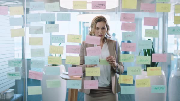 Beautiful business woman using sticky notes brainstorming ideas ...