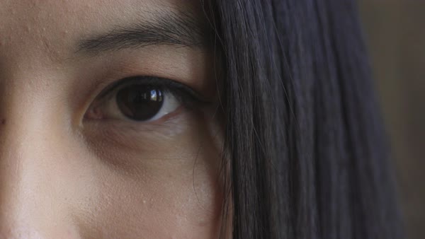 Close up of young asian woman eye blinking looking at camera female ...